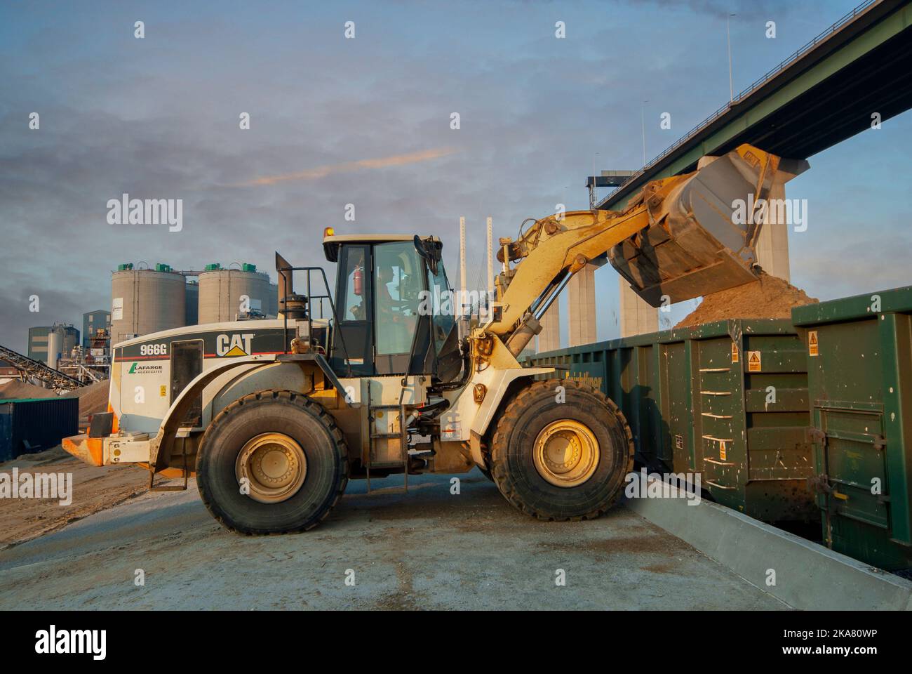 Caterplillar wheel loader loading aggregate wagons on a Freightliner ...