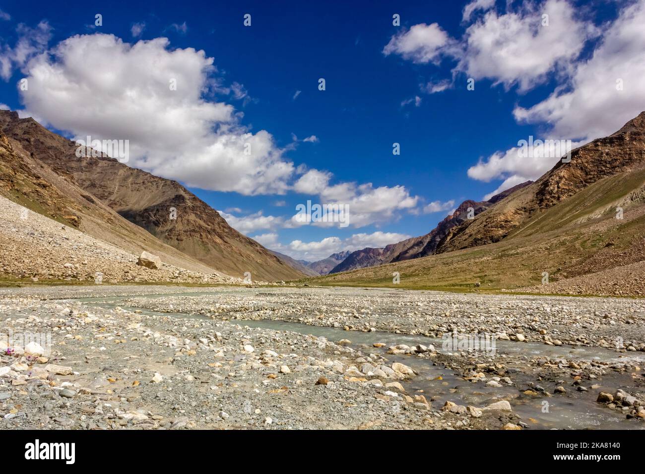 The wide river bed of the Kargyak river with the mountains of the ...