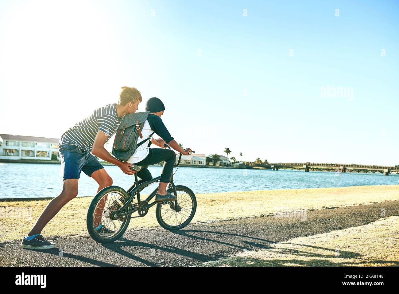 Sometimes you need a push from your older brother. Full length shot of ...