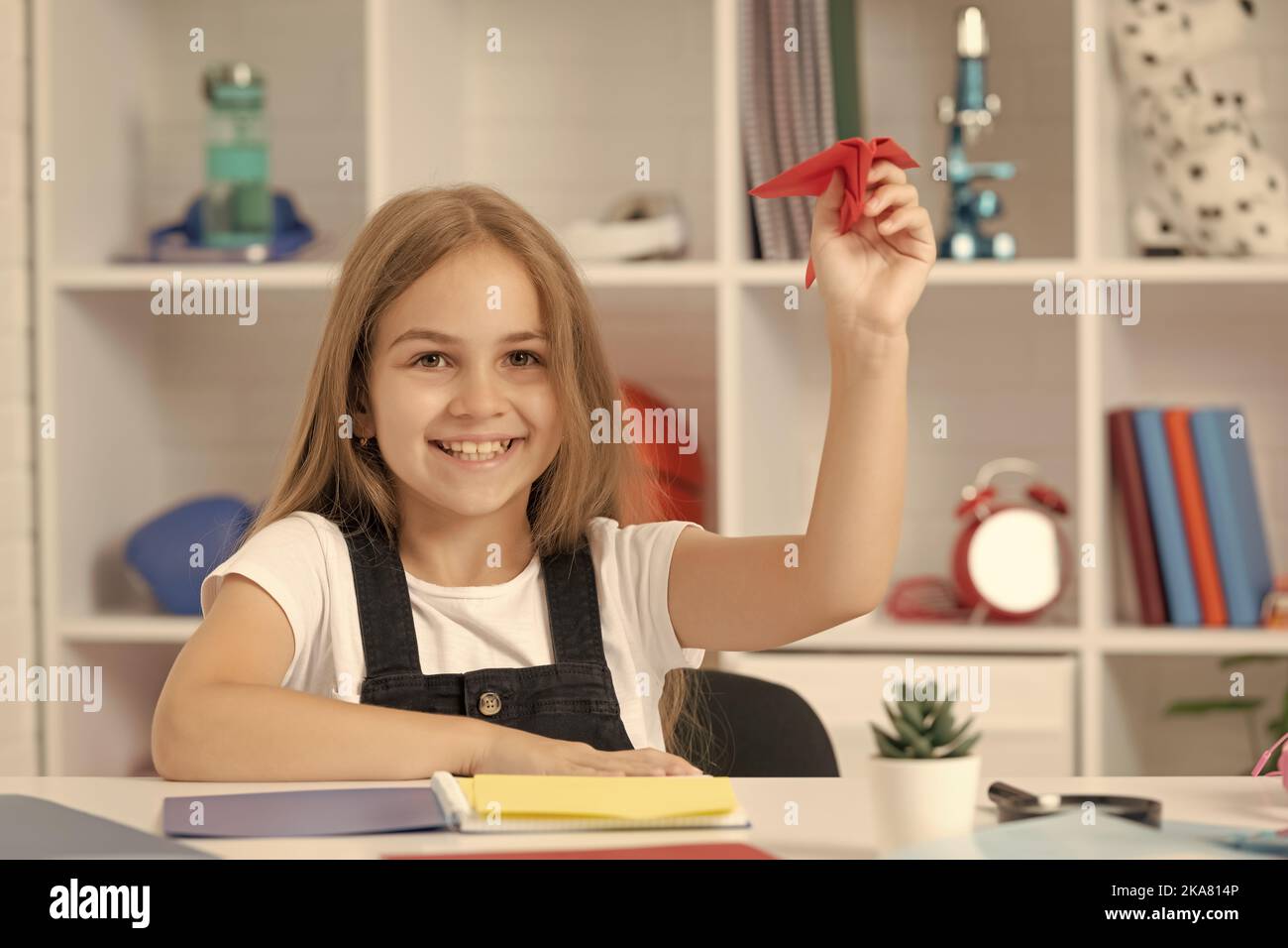 glad child play with paper plane in school classroom Stock Photo - Alamy