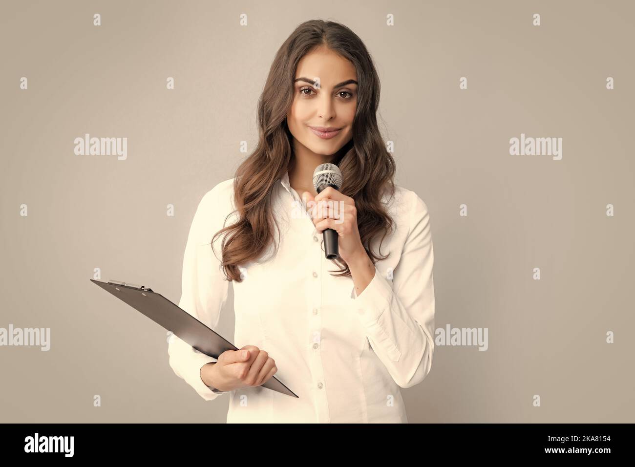Smiling young woman as reporter with microphone and clipboard. Female ...