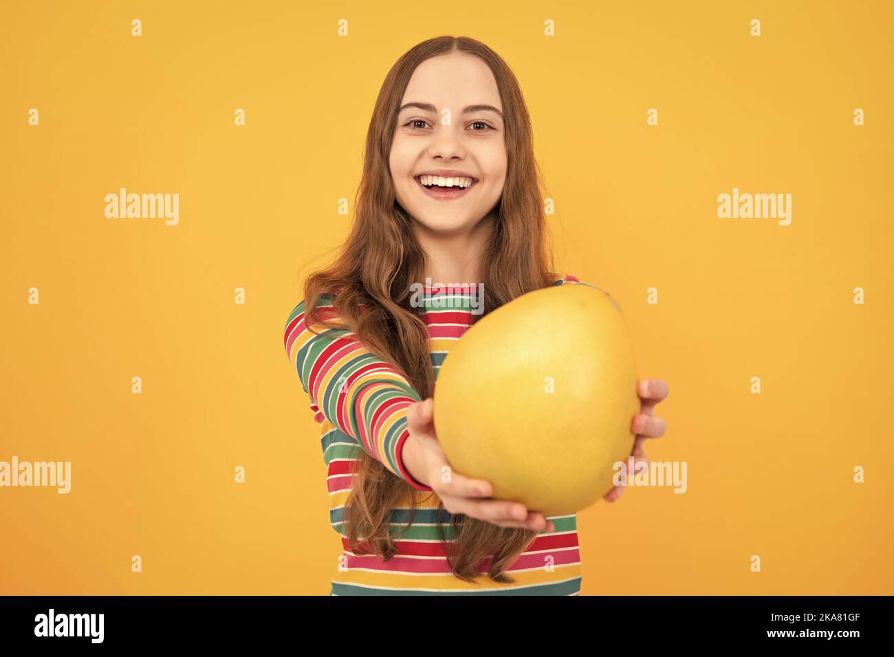 Teenage girl hold citrus fruit pummelo or pomelo, big grapefruit ...