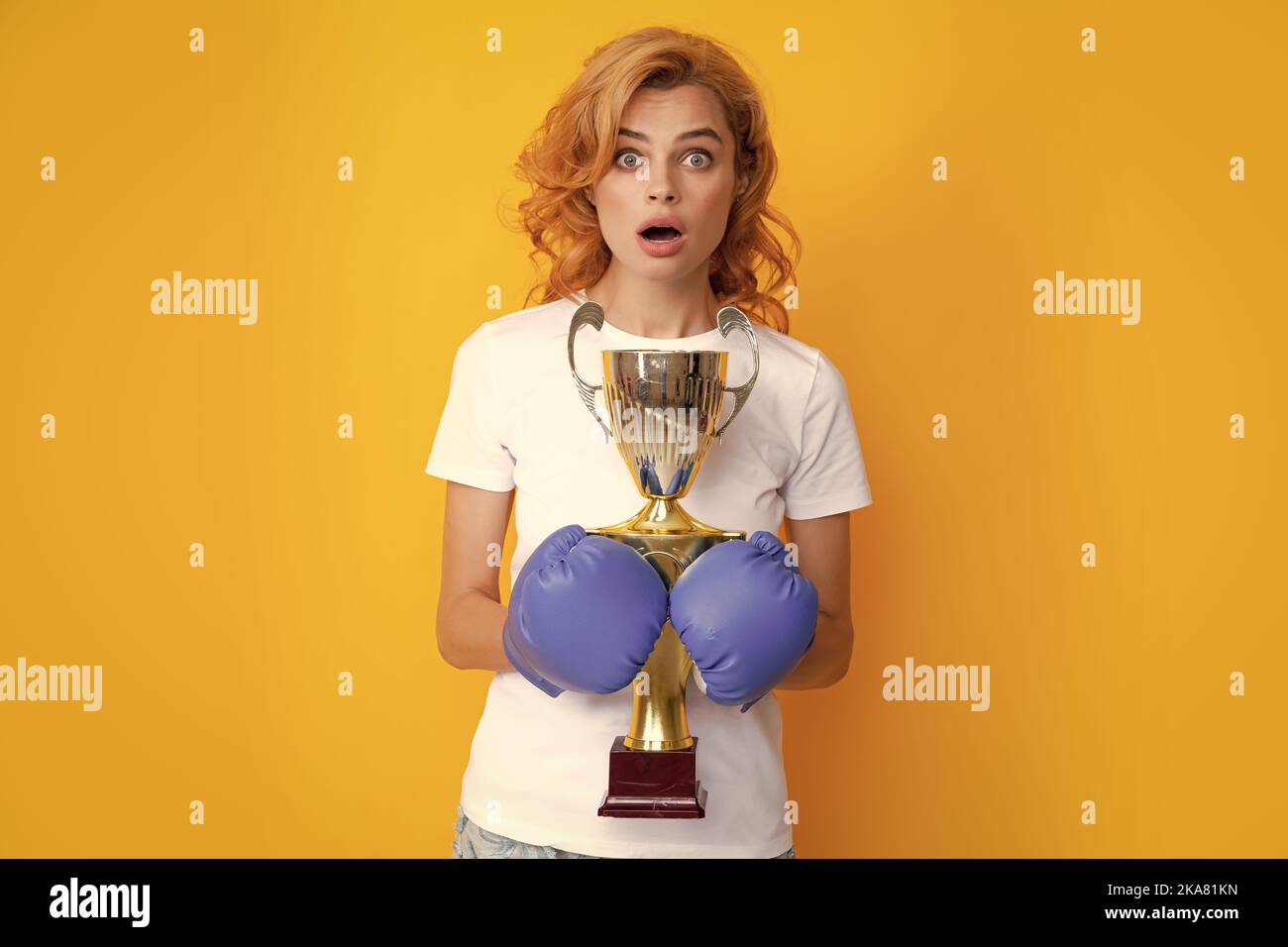 Woman in boxing gloves hold champion winner cup trophy. Funny girl in ...
