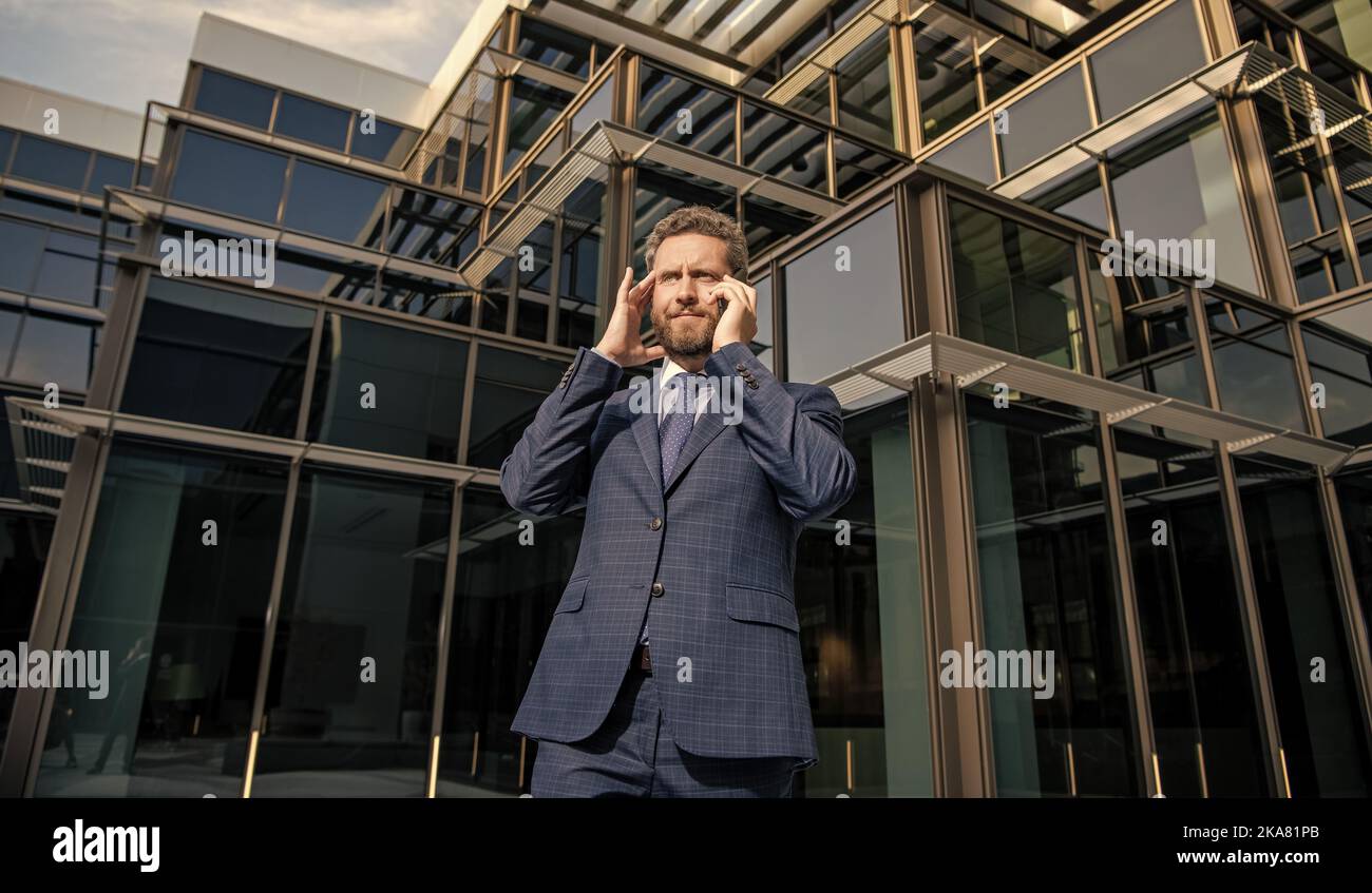worried and stressed mature business man in formalwear talking on phone ...