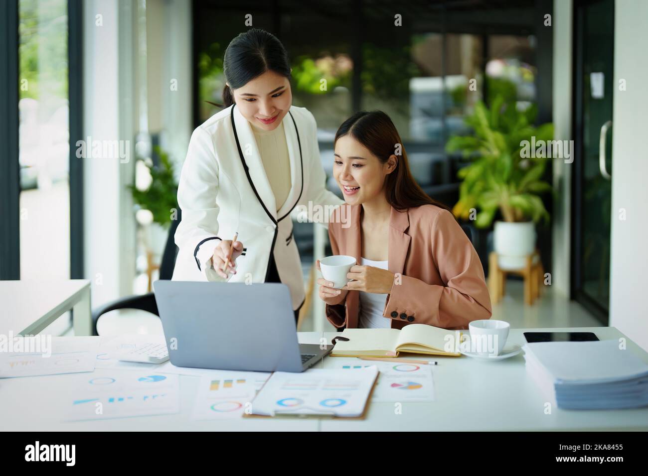 Portrait of two female employees using computers during work Stock ...