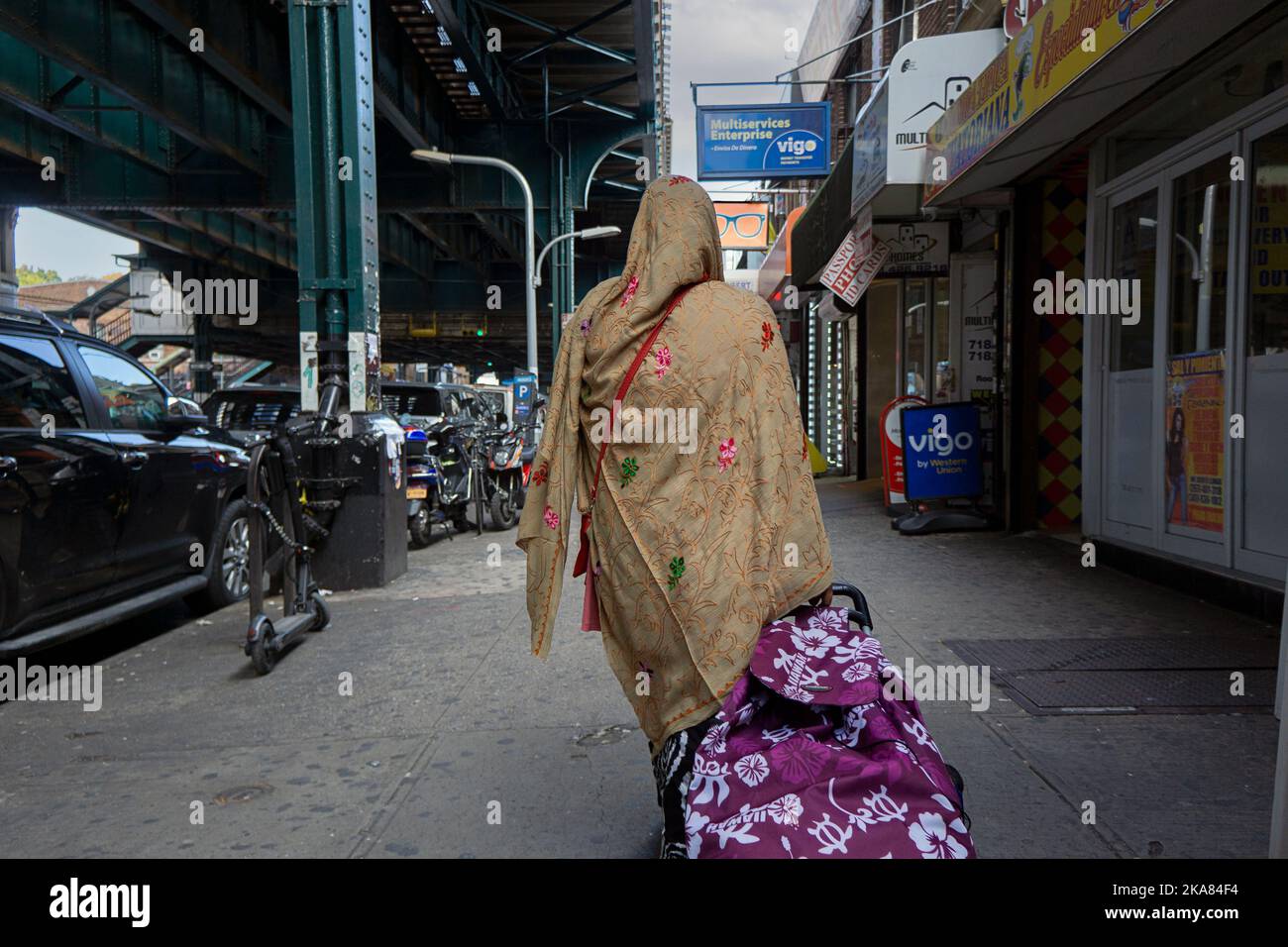 An anonymous Muslim woman photographed from behind walks Eastward on ...