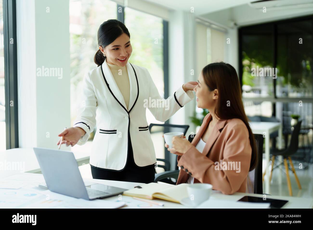 Portrait of two female employees using computers during work Stock ...