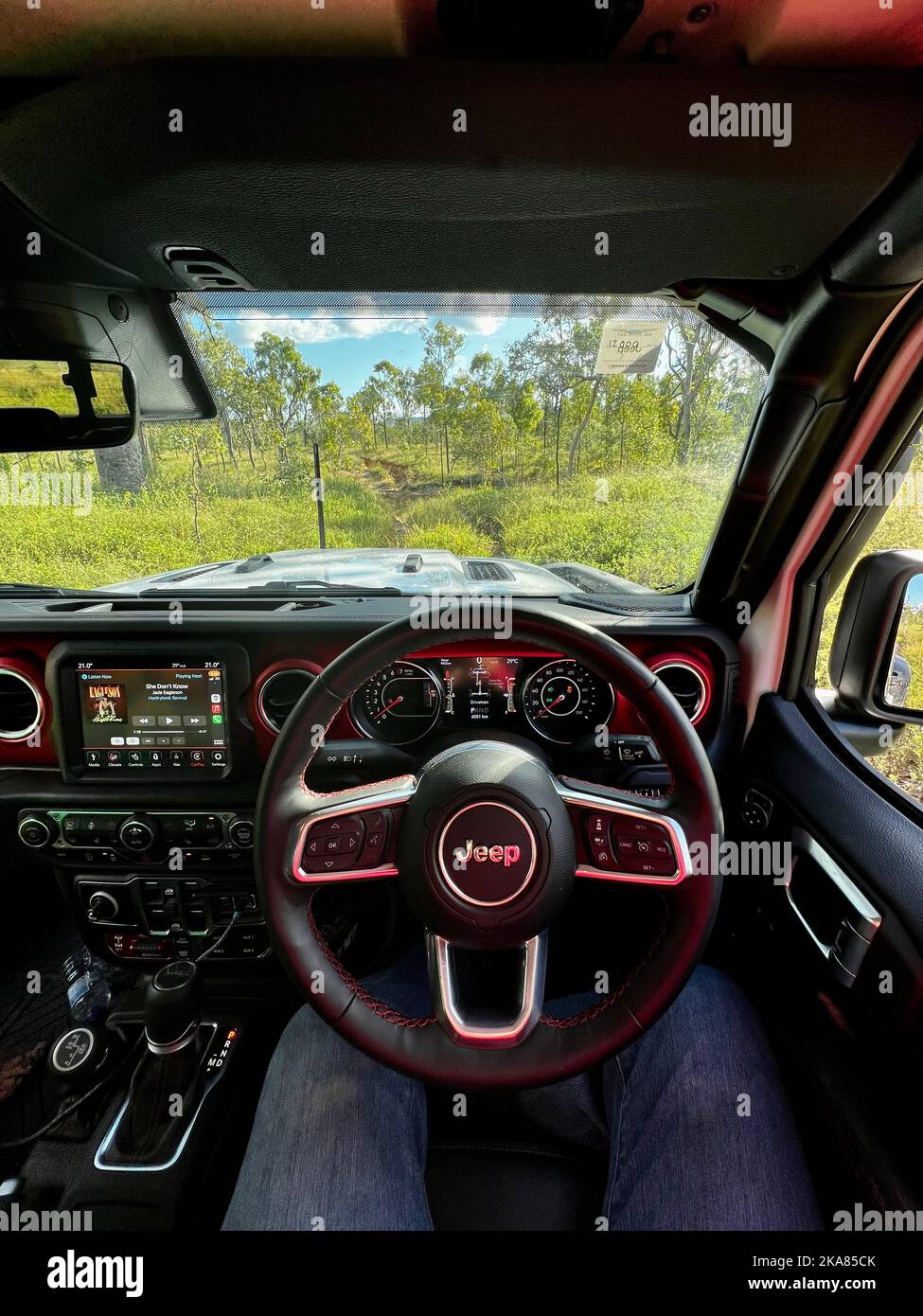 A vertical closeup of an interior of a Jeep car with its wheel and ...