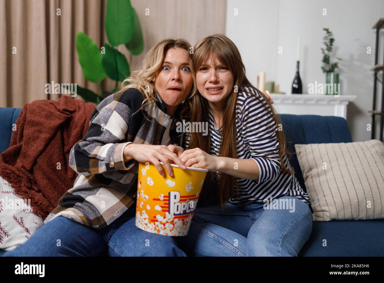 Two surprised women watching something on tv at home Stock Photo - Alamy