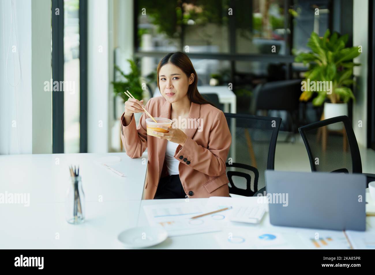 Portrait of a woman taking a break to eat instant noodles Stock Photo ...