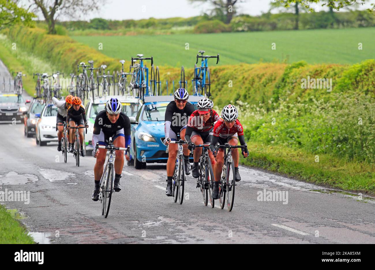 Racing cyclists with support vehicles with cycles on their roofs ...