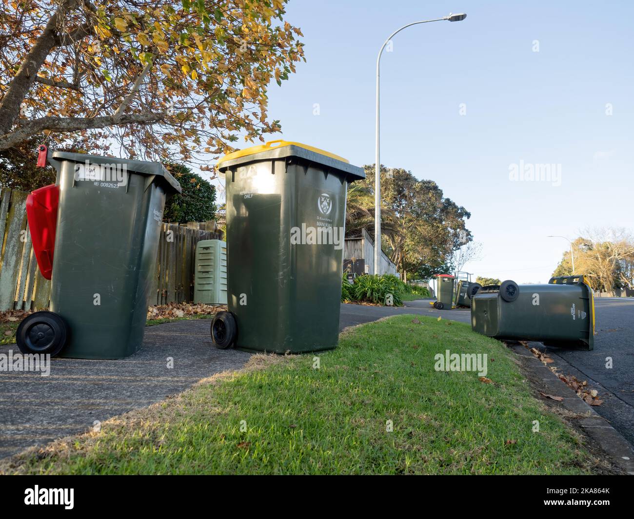 View of rubbish wheelie bins toppled by strong wind laying on ground ...