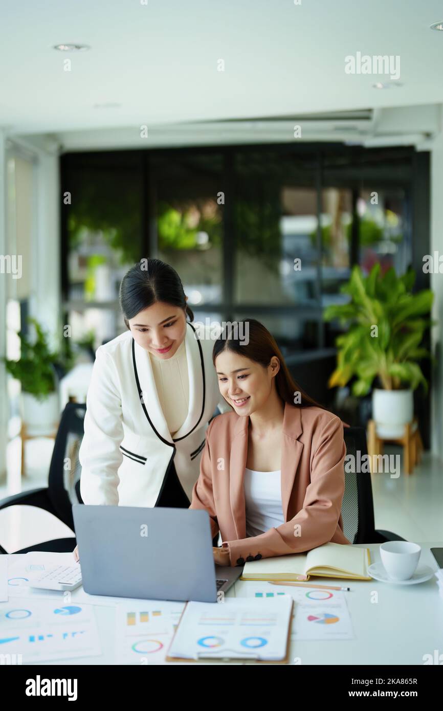 Portrait of two female employees using computers during work Stock ...
