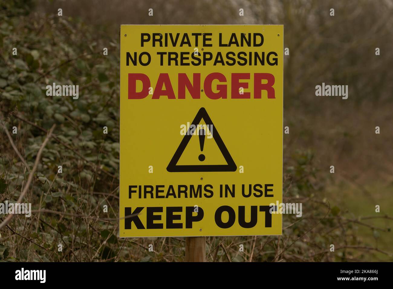 Private Land, Yellow warning sign, showing danger as firearms in use ...