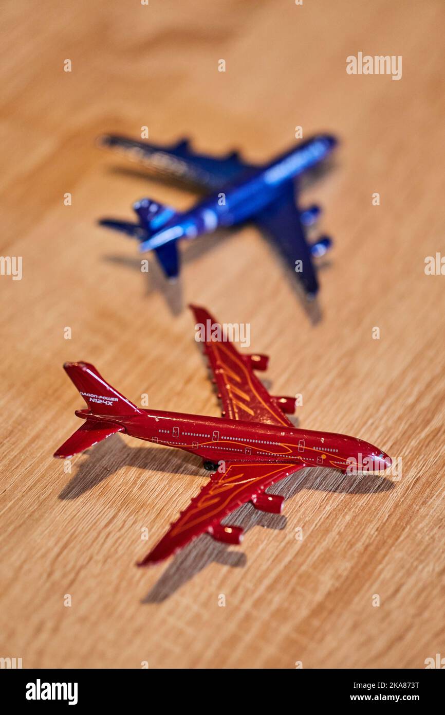 A closeup shot of a two toy model transport airplanes on a wooden table ...