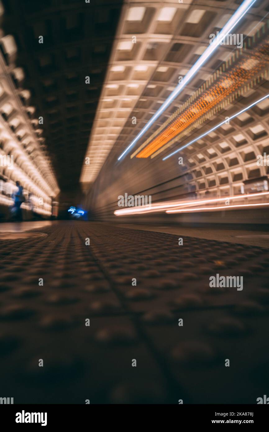 A vertical shot with long exposure of a subway tunnel with the lights ...