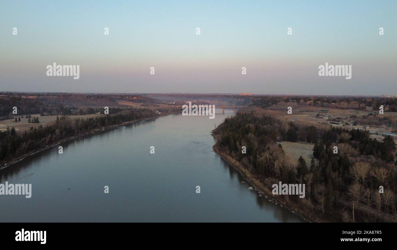 An aerial view of a river flowing in a town at sunset in Edmonton ...