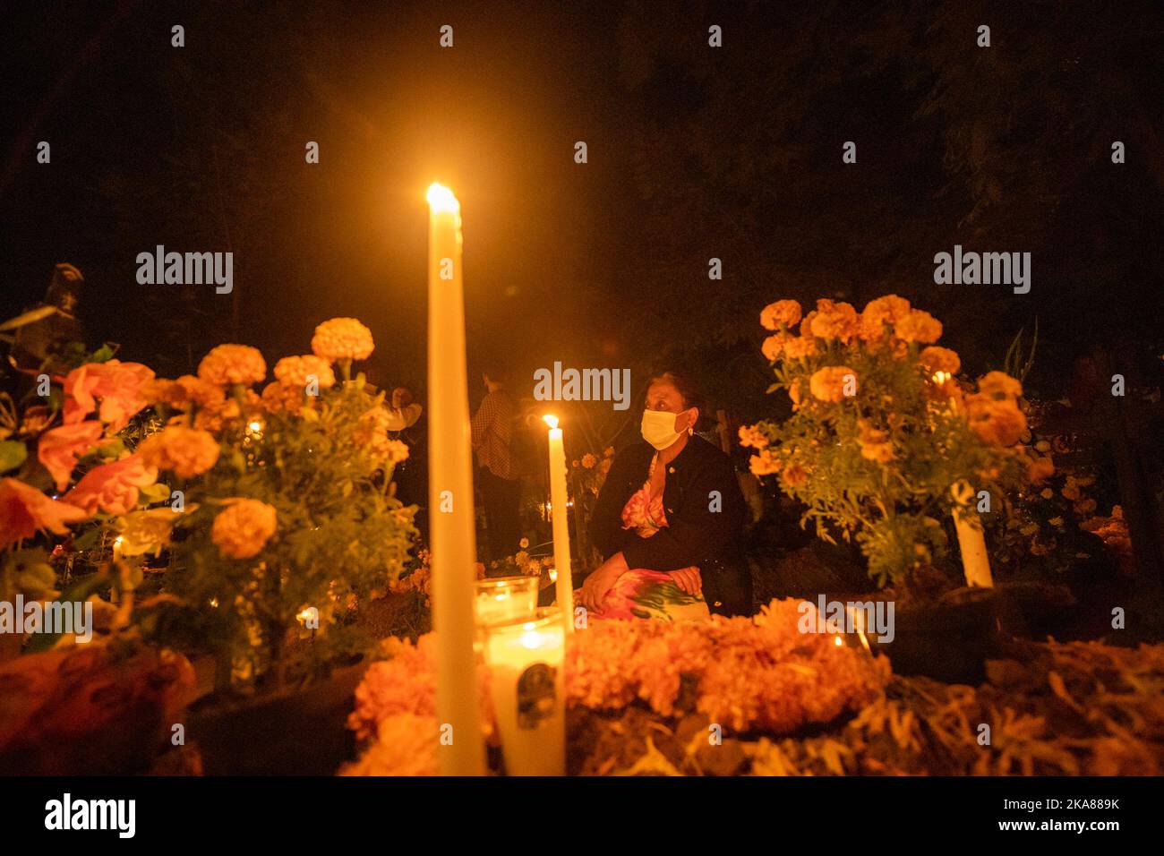 Oaxaca, Mexico. 31st Oct, 2022. A woman sits at a grave in a cemetery ...