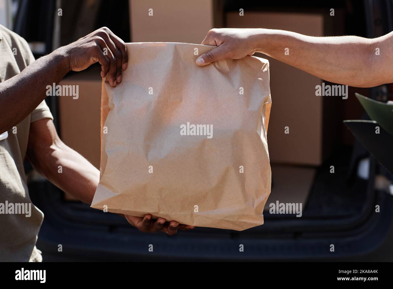 Black delivery man holding package hi-res stock photography and images ...