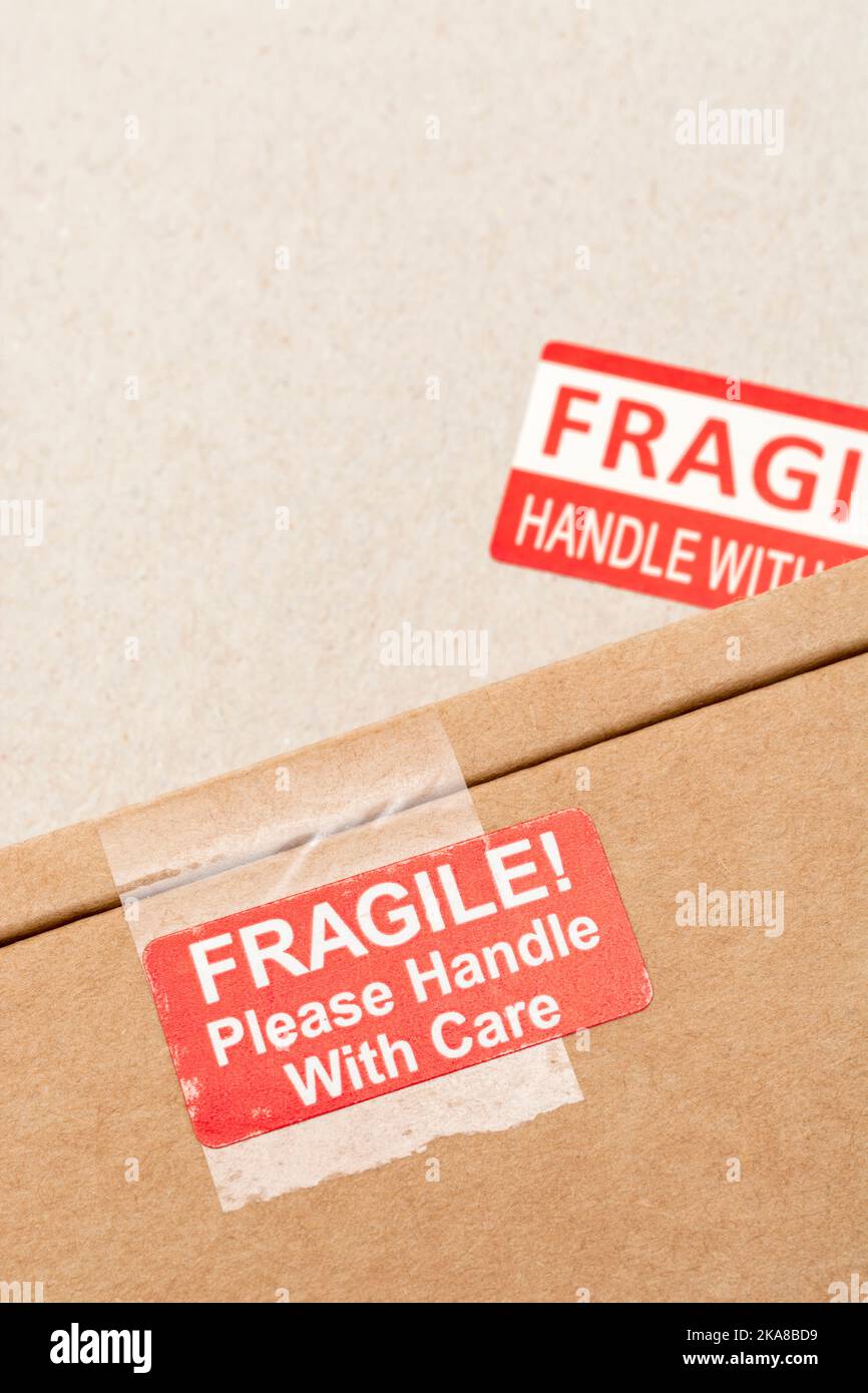 Brown cardboard shipping boxes with red and white adhesive paper label ...