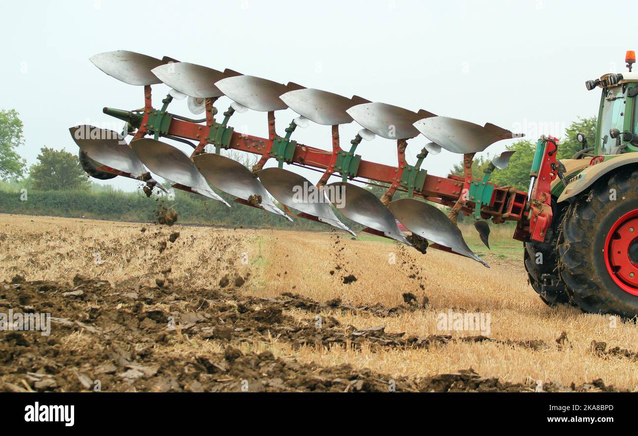 Tractor and plough attached. Various shots of tractor ploughing a field ...