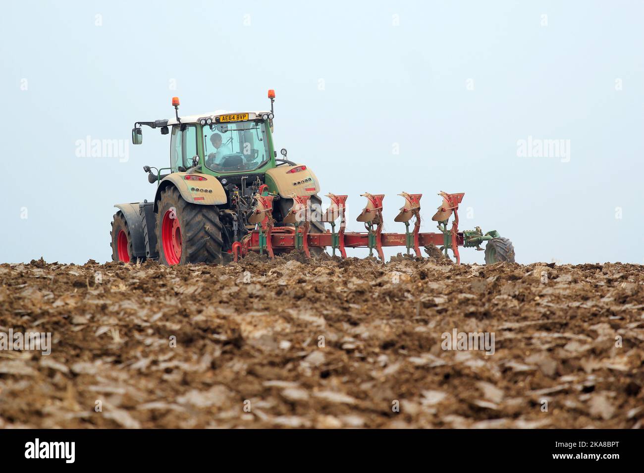 Tractor and plough attached. Various shots of tractor ploughing a field ...