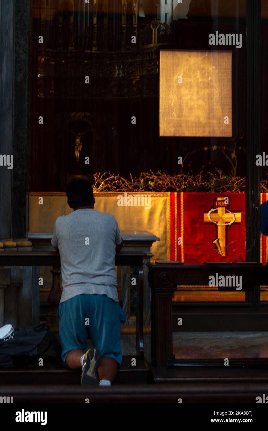Young man kneeling before image of the Turin Shroud in Turin Cathedral ...