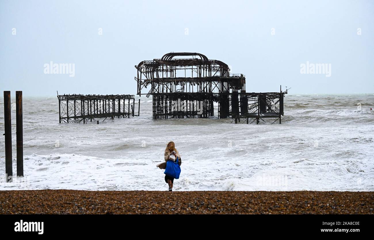 Brighton UK 1st November 2022 - A walker passes by after more parts of ...
