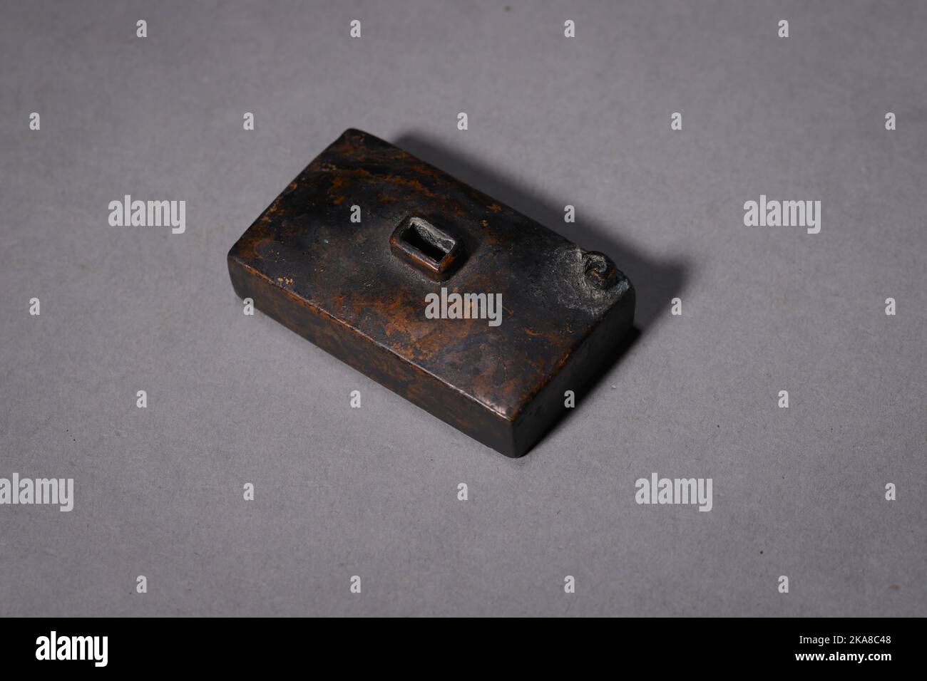 An antique metal ink holder for Chinese calligraphy on a gray ...