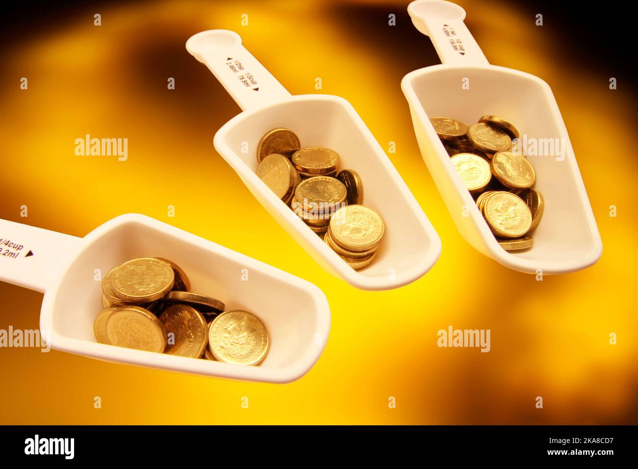 Measuring Spoons with Coins Stock Photo - Alamy