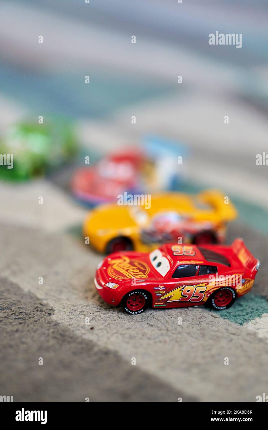 A vertical shallow focus of toy cars on a carpet - Lightning McQueen ...