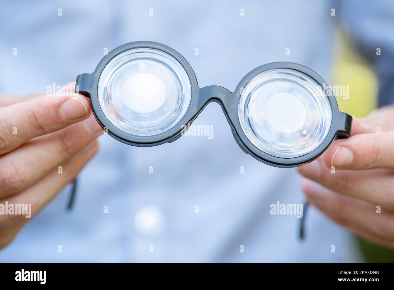 Man holding up large toy glasses with big thick lenses, simple glasses ...