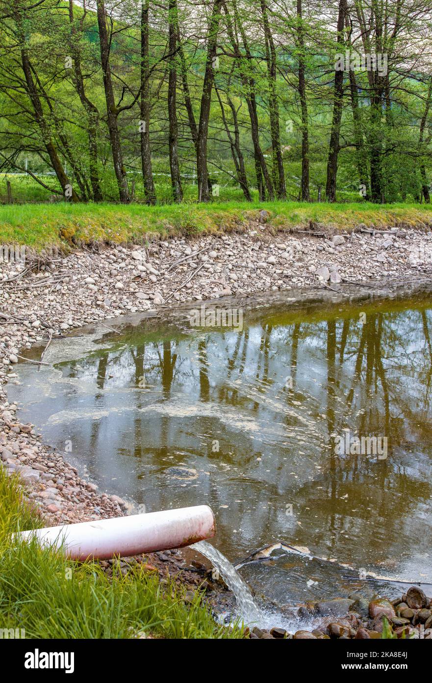a pipe through which polluted water flows in nature, dirt, toxic Stock ...