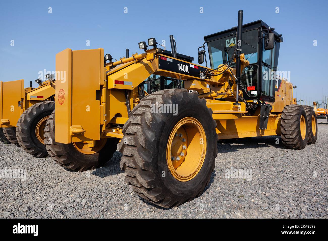 A big Caterpillar 140K motor grader in blue sky background Stock Photo ...