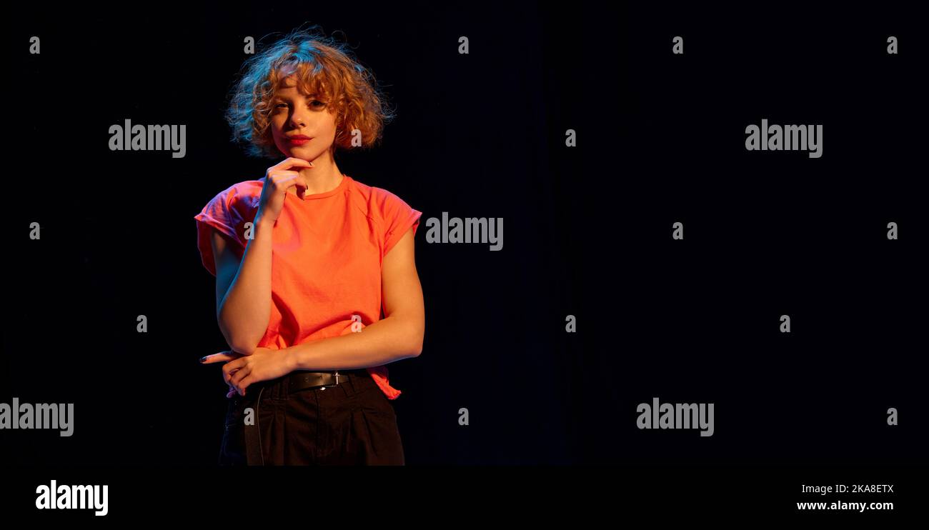 Young sad calm girl with short curly red hair posing isolated over ...