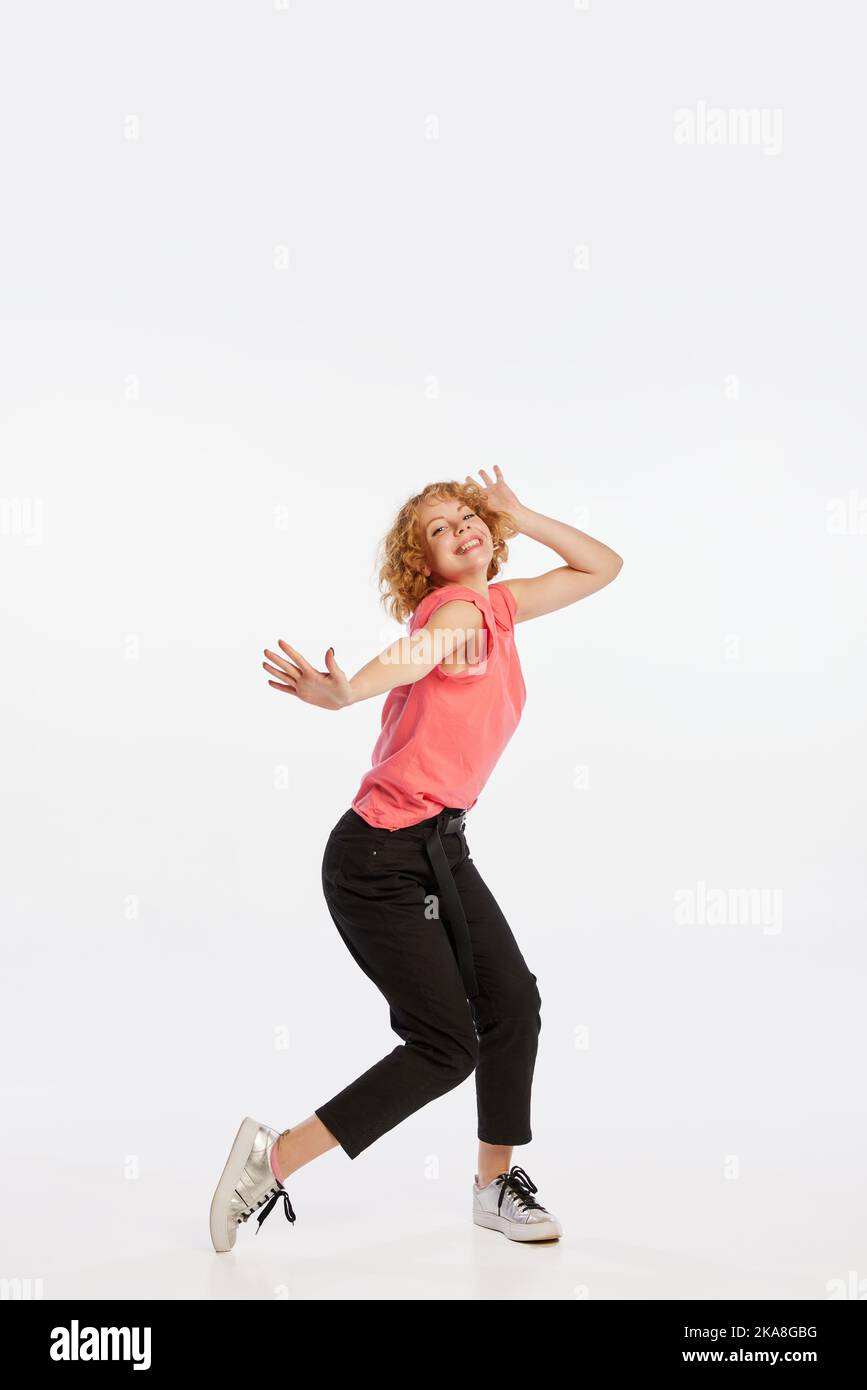 Excited beautiful young redheaded woman dancing isolated on white ...