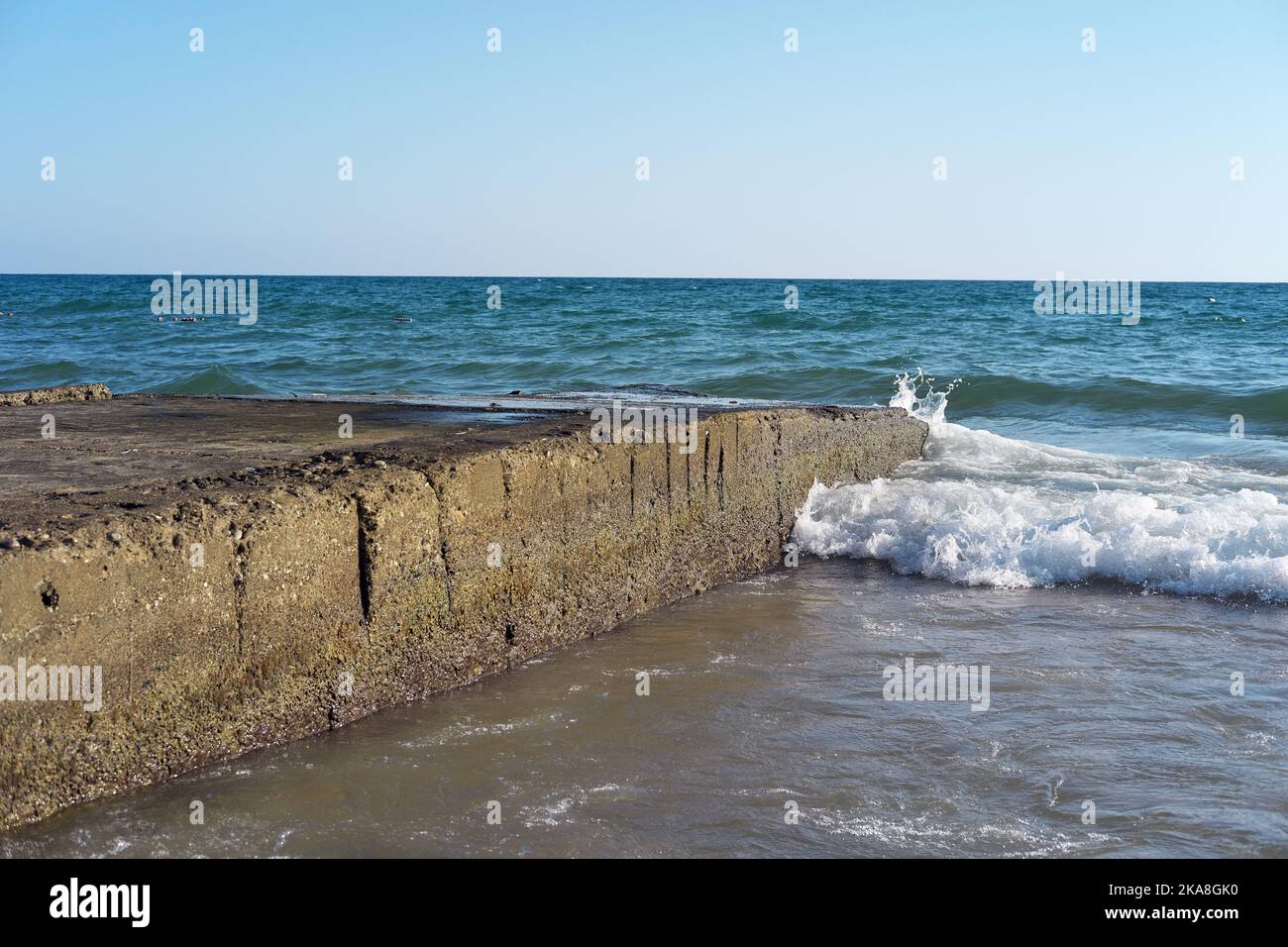 Waves hitting stones of an old dock Stock Photo - Alamy
