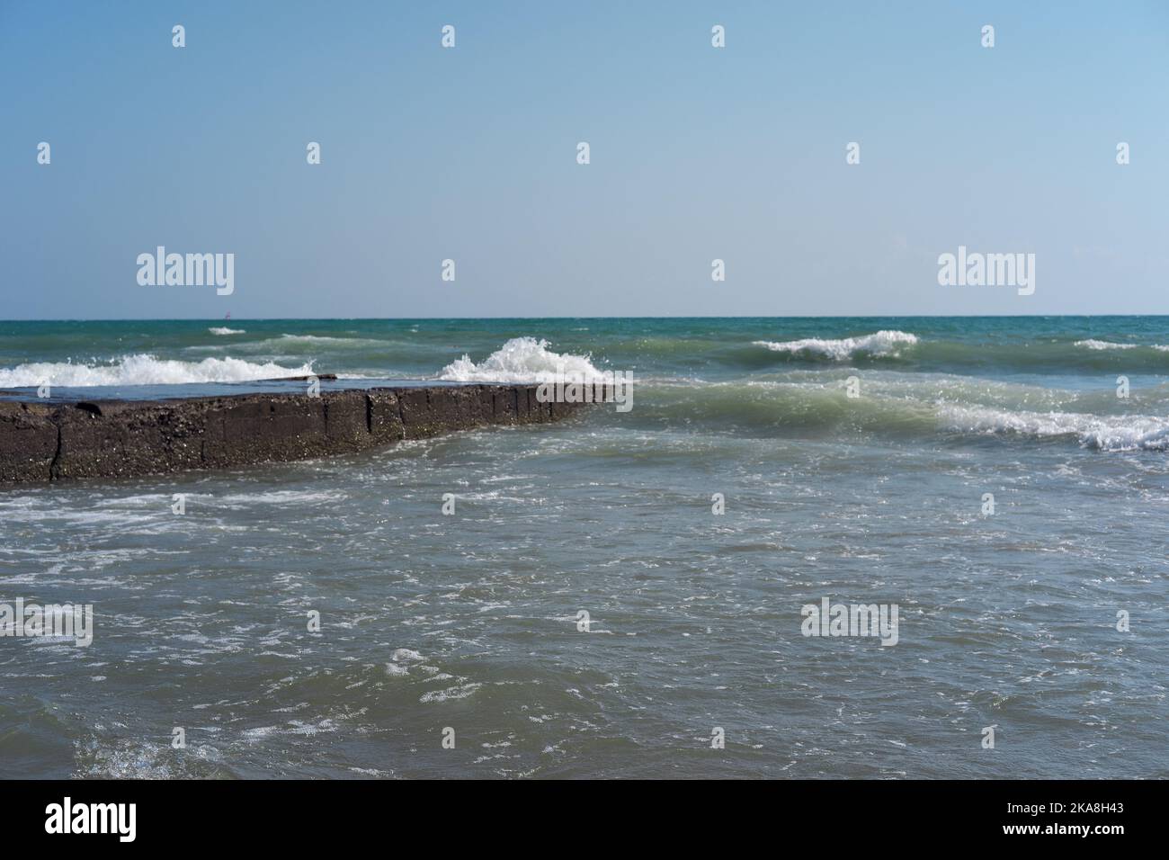 Waves hitting stones of an old dock Stock Photo - Alamy