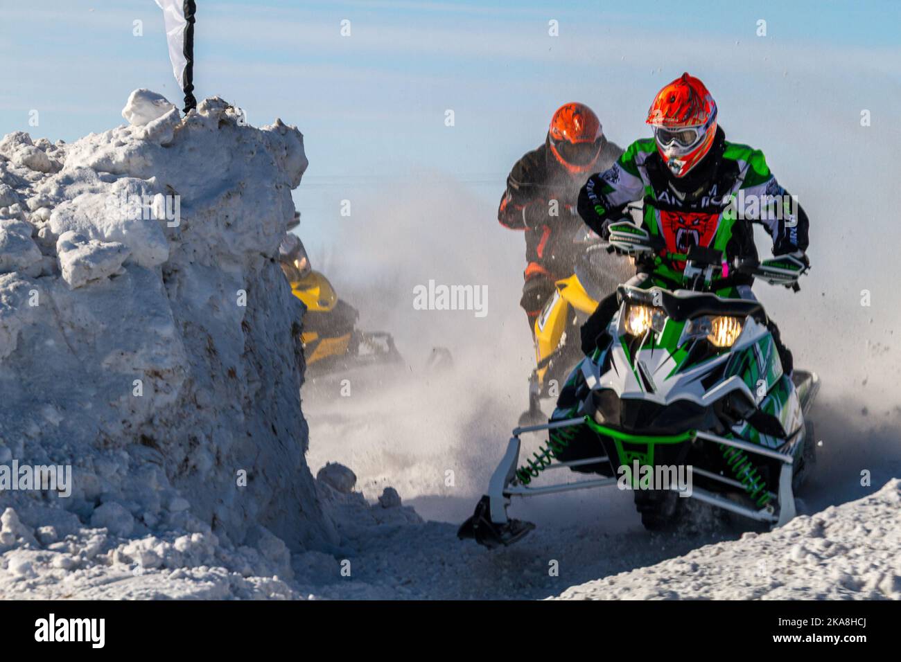 Two snowmobile racers rounding a corner on the track fighting for the ...