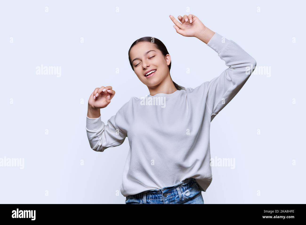 Cheerful dancing teenage girl on white studio background Stock Photo ...