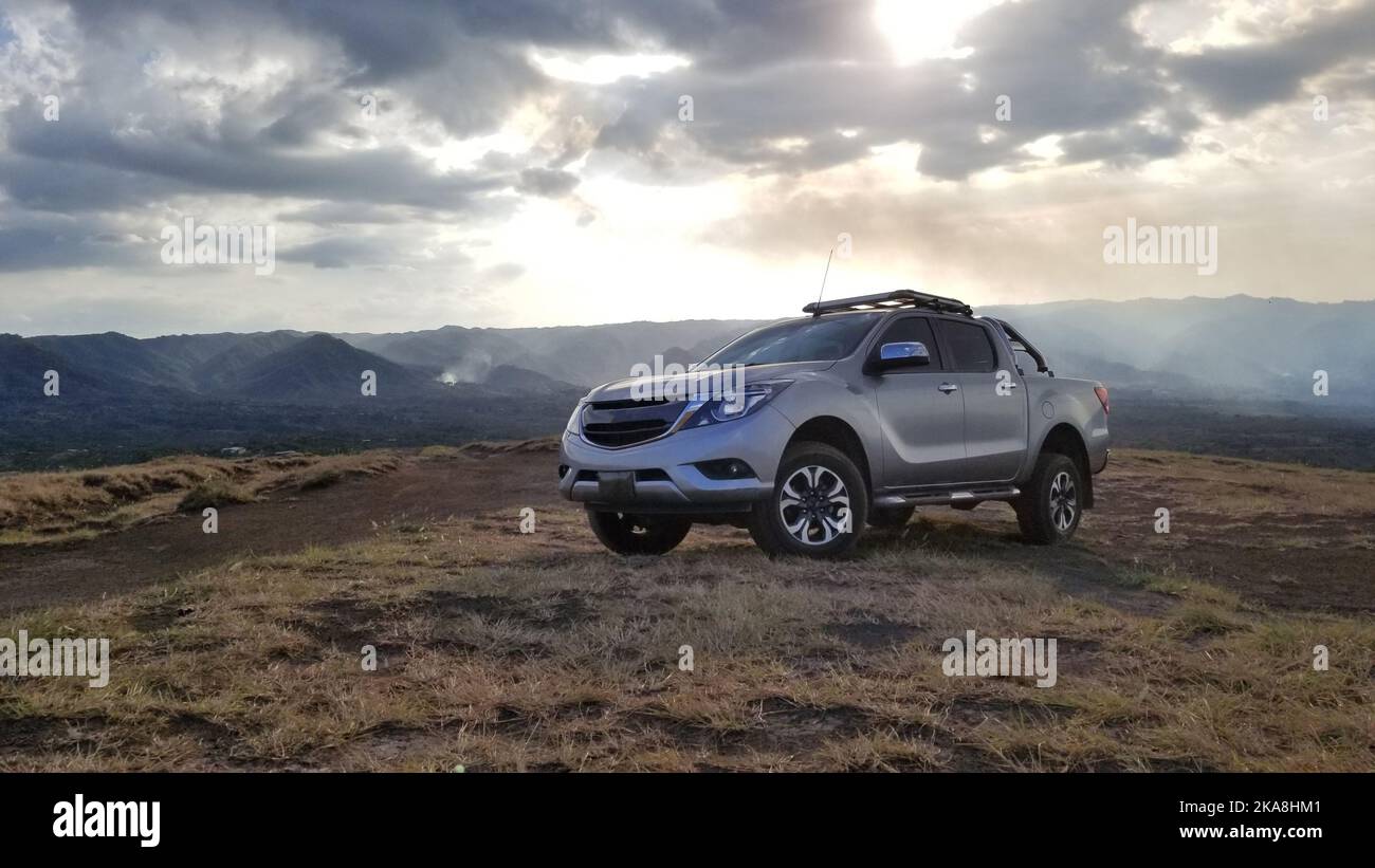 Grey pick up truck on volcano background in sunset time Stock Photo - Alamy
