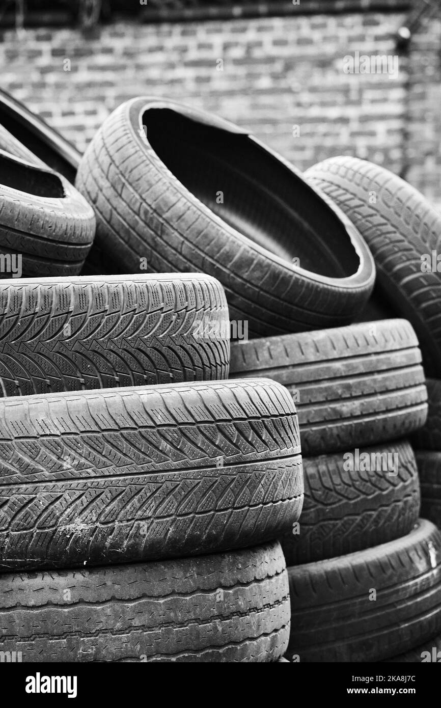A vertical grayscale shot of many used old car tires- perfect for ...