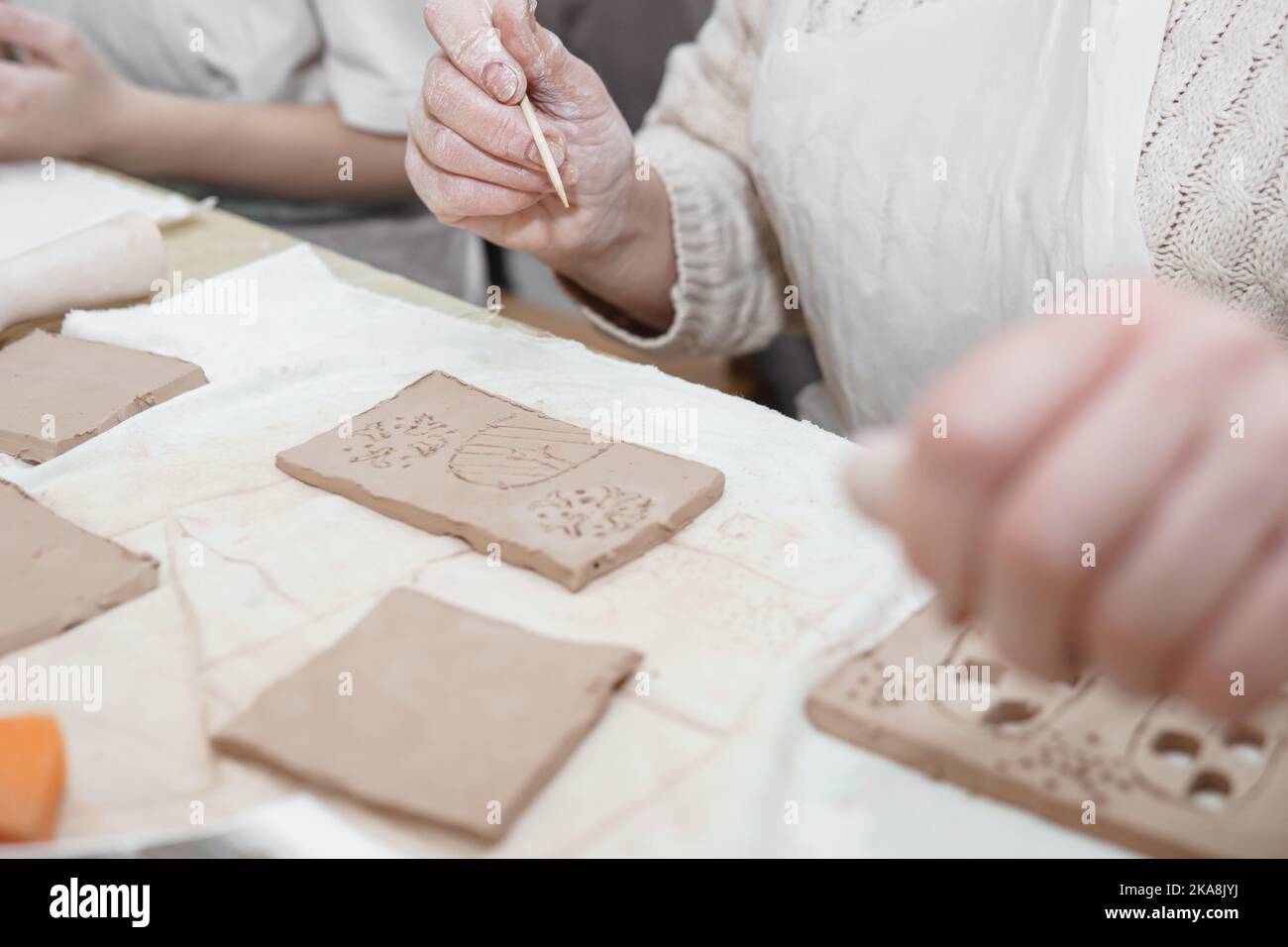 Women's hands knead clay, drawing elements of the product. Production ...