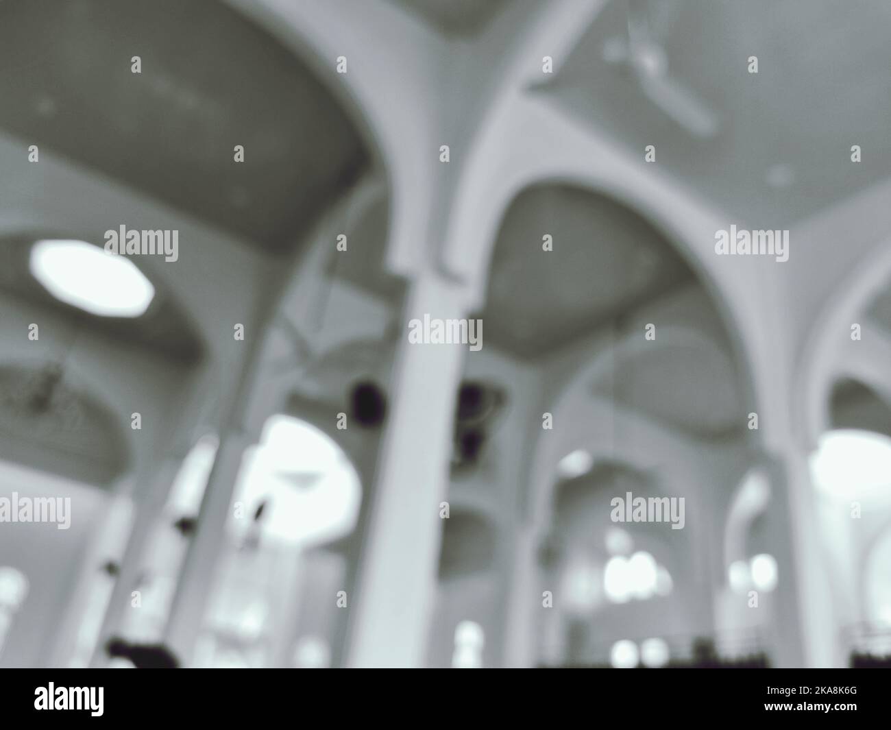 A low angle shot of a white blurry interior of a mosque with pillars ...