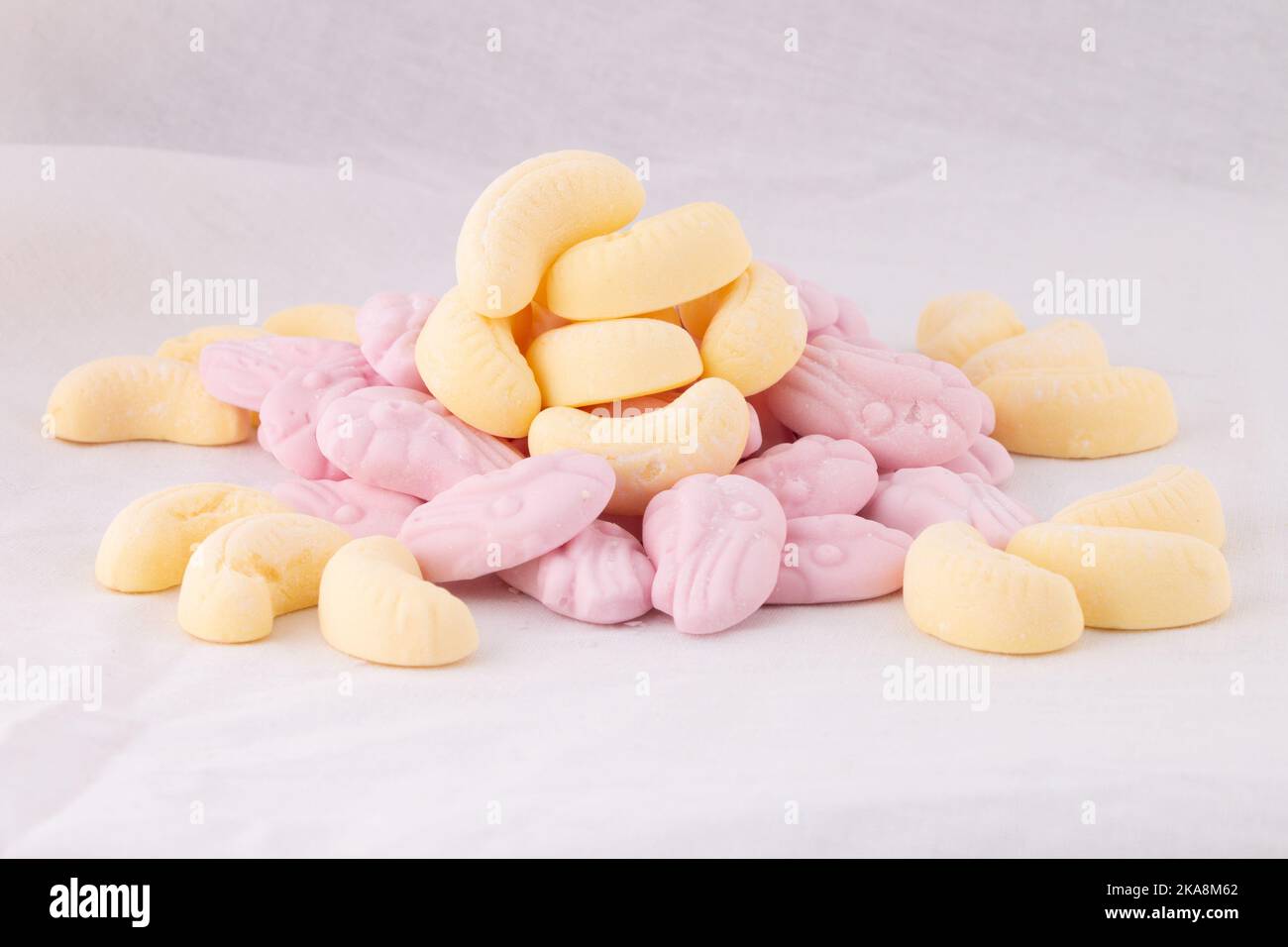 Delicious yellow banana and raspberry shrimp sweets on white background ...