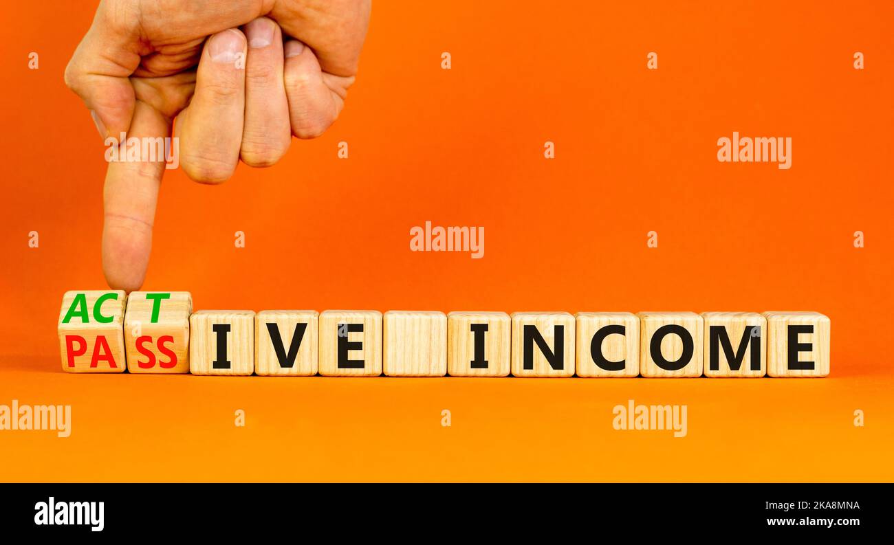 Passive or active income symbol. Businessman turns wooden cubes and ...