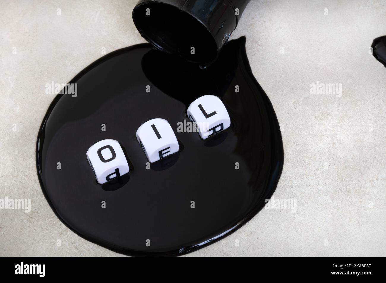 Oil crisis depiction with toys, oil barrel and spill on gray with ...