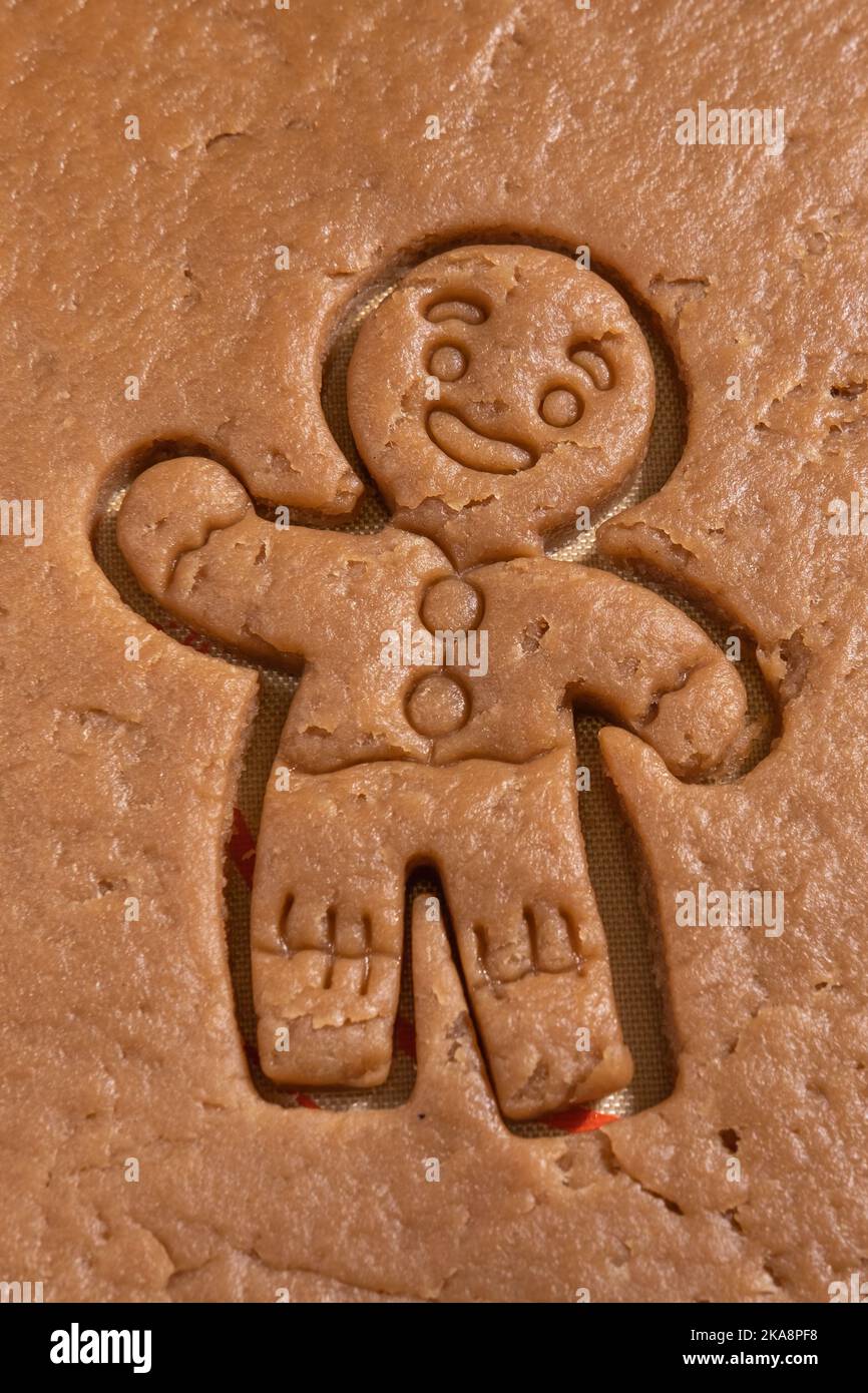 Gingerbread man carved from raw gingerbread dough. Making homemade ...
