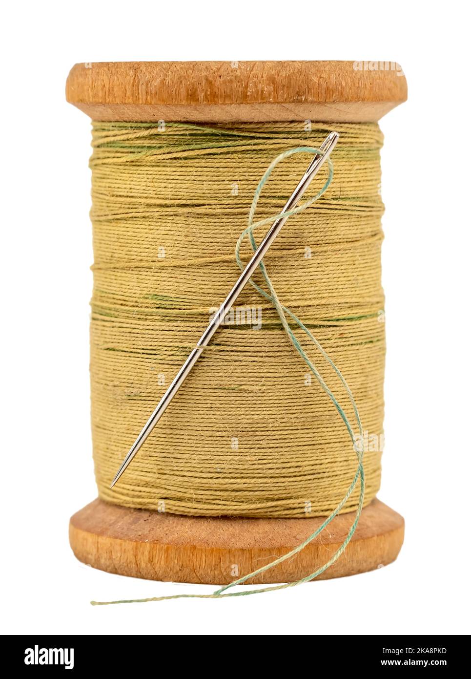 An old wooden spool of thread and a needle on a white background close ...