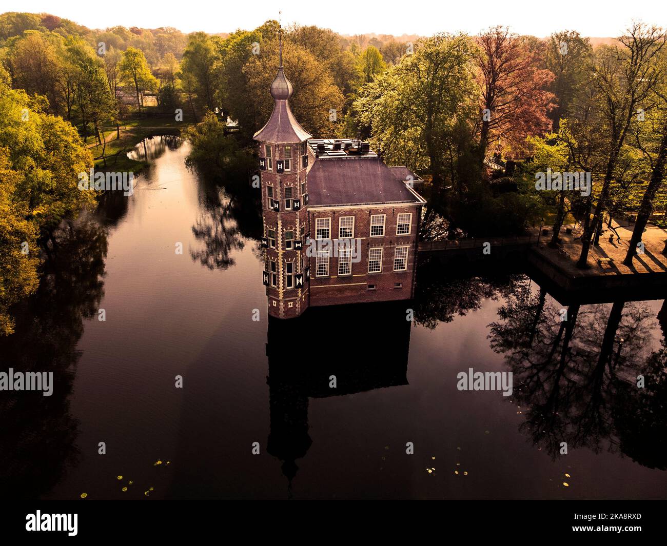 An aerial view of a beautiful castle in a forest surrounded by water in ...